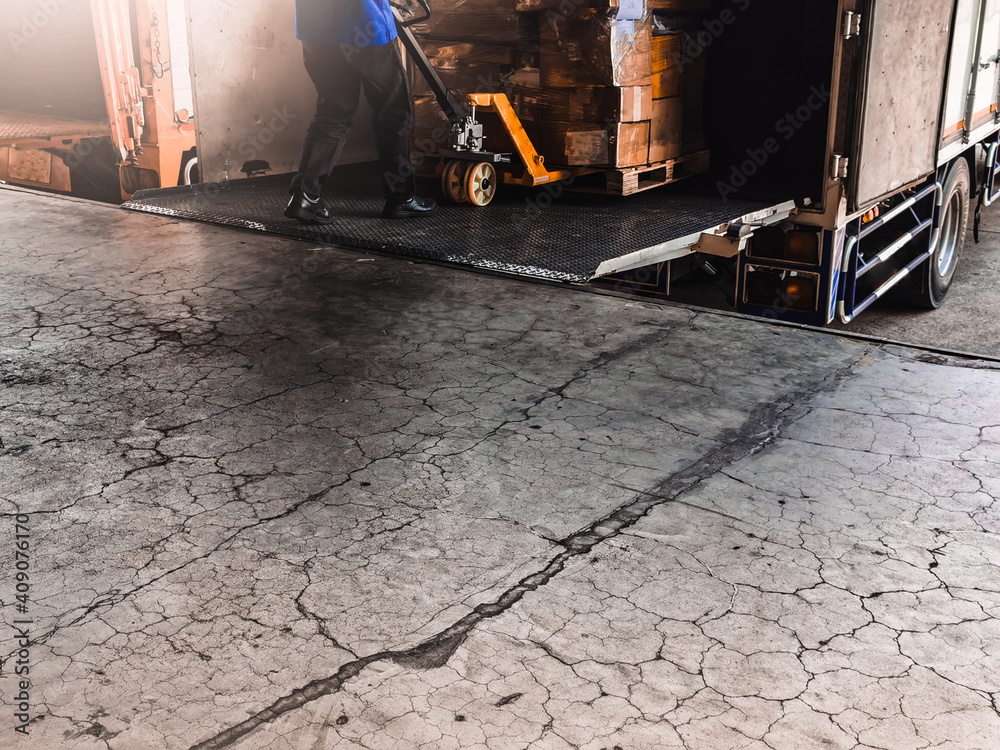 Worker driving forklift loading shipment carton boxes goods on wooden ...
