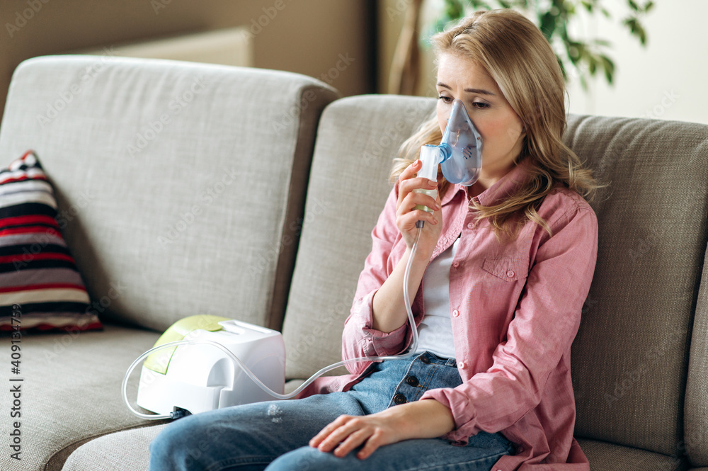 A worried sick caucasian woman with an inhaler. Unhealthy female doing ...