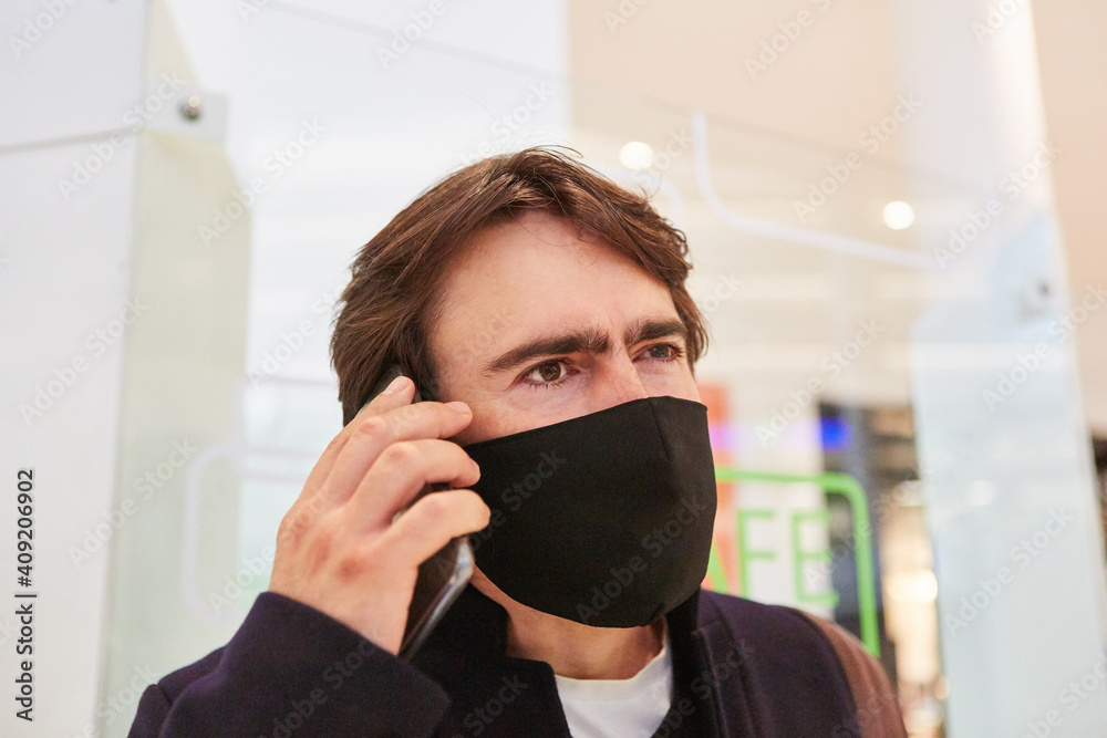 Man with face mask is on the phone with the smartphone Stock Photo ...
