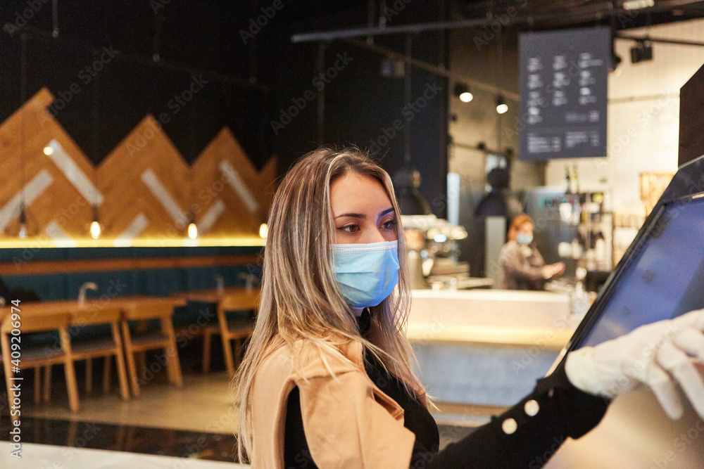 Waitress with mask in the restaurant operates touchscreen Stock Photo ...
