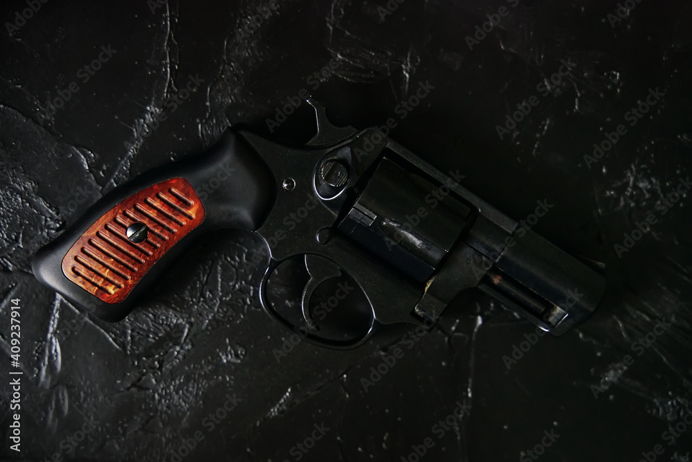 Vintage gun on concrete textured table. Revolver with wooden handle and ...