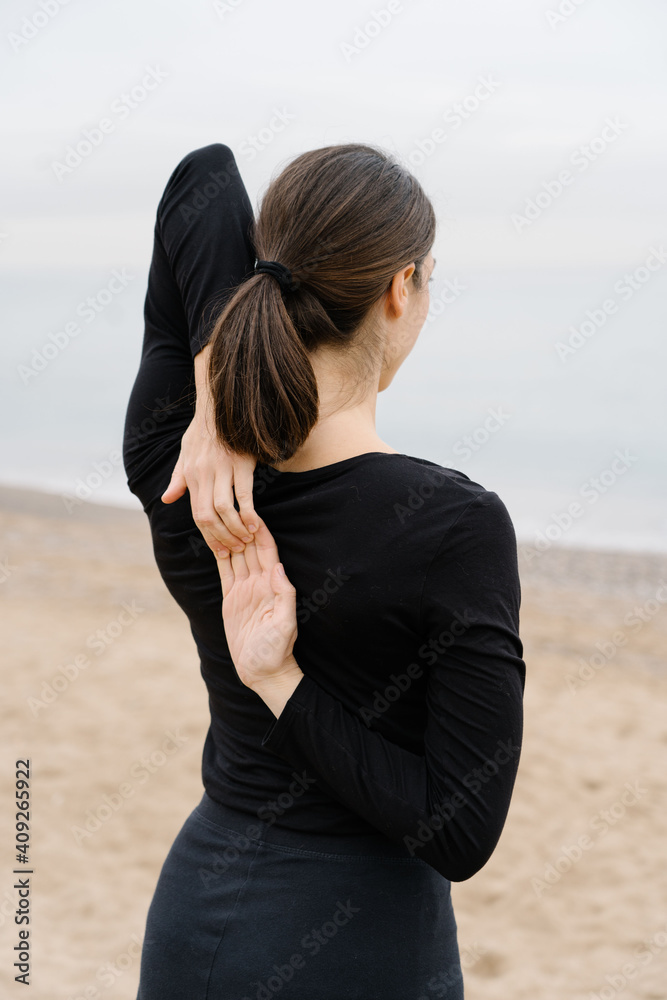 Woman making exercises with hands over her back. Stock Photo | Adobe Stock