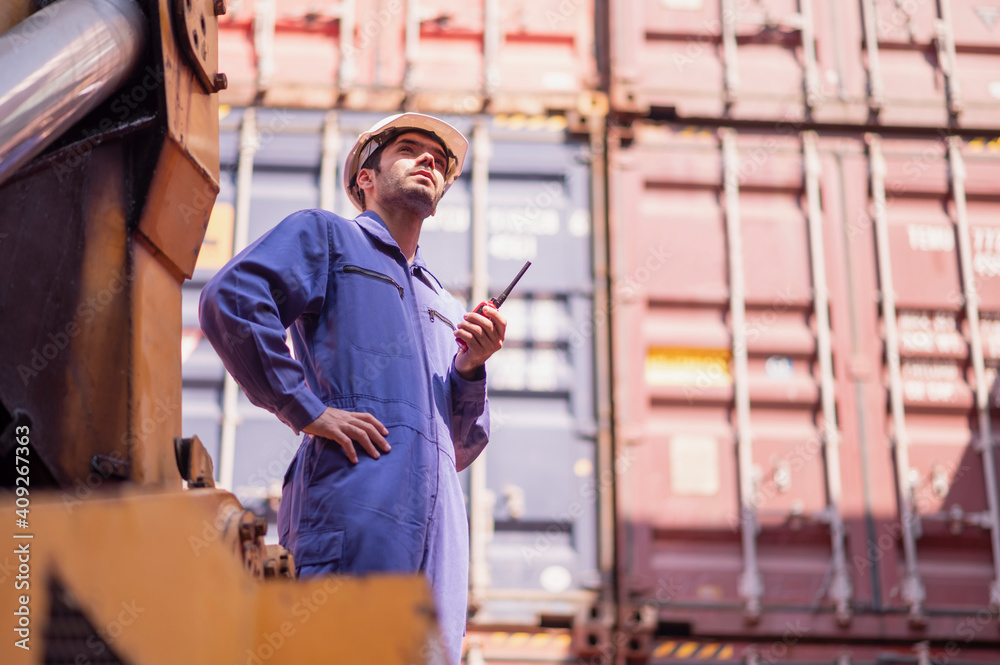 The foreman controls the loading of container boxes from a cargo ship ...