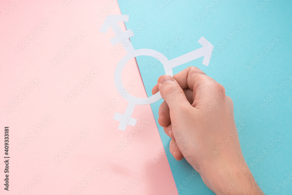 Hand holding a sign of trans people on pink and blue background Stock ...