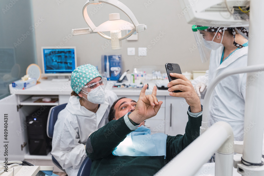 Patient taking a selfie in the dental office.Focus on the smart phone ...