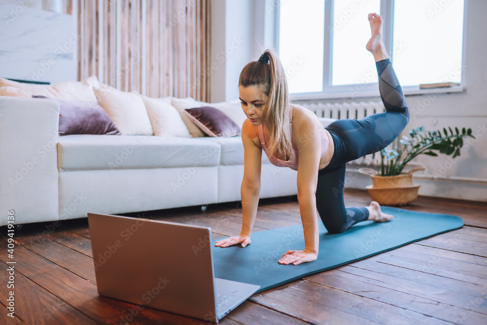 Beautiful sporty fit woman do exercise and watch online tutorial on ...