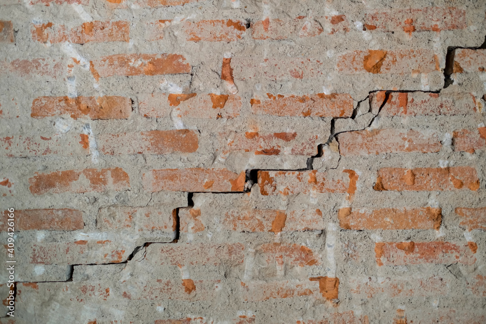 Brick wall cracks in concrete cement wall in the house where no people ...