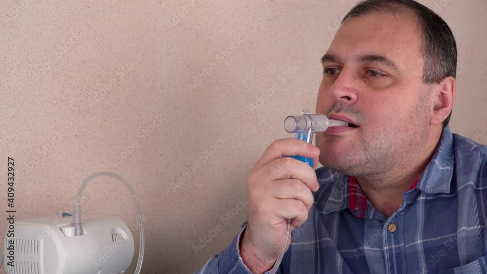 adult person makes inhalations with the help of nebulizer. patient ...