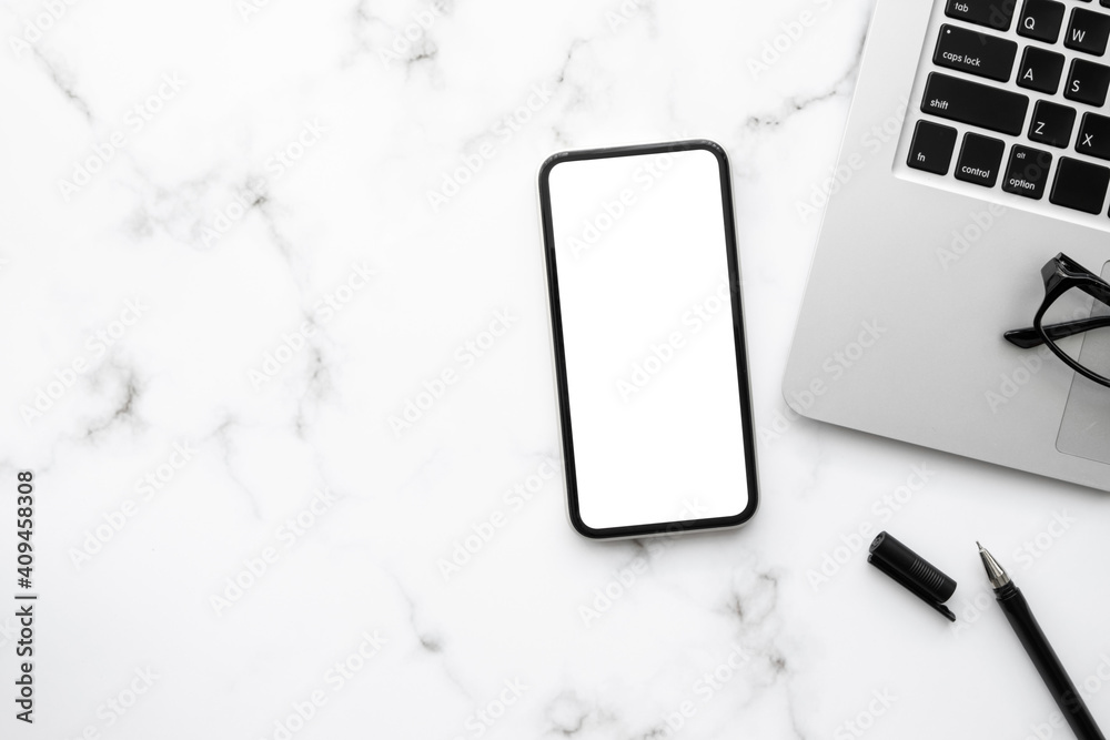 Smartphone with blank screen is on top of white marble office desk ...