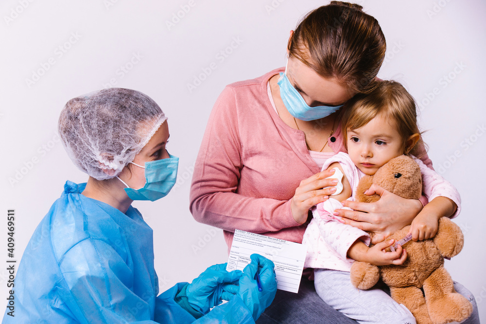 Mom holds her little daughter with a toy and calms down after the ...