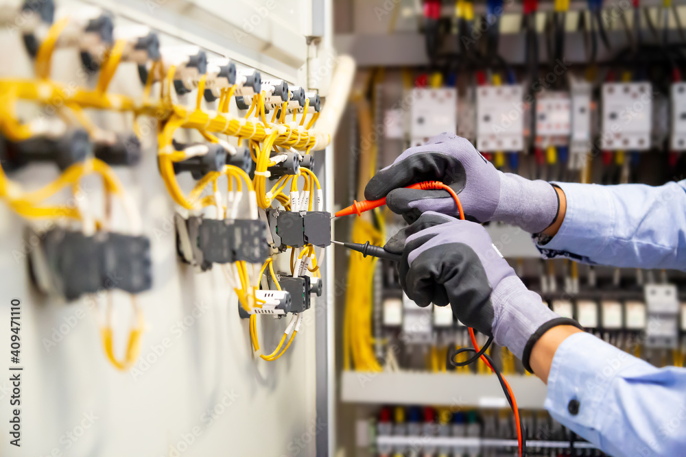 Electrical engineer using digital multi-meter measuring equipment to ...