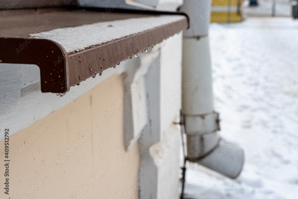 The facade of the building and window sills are covered with ice and ...