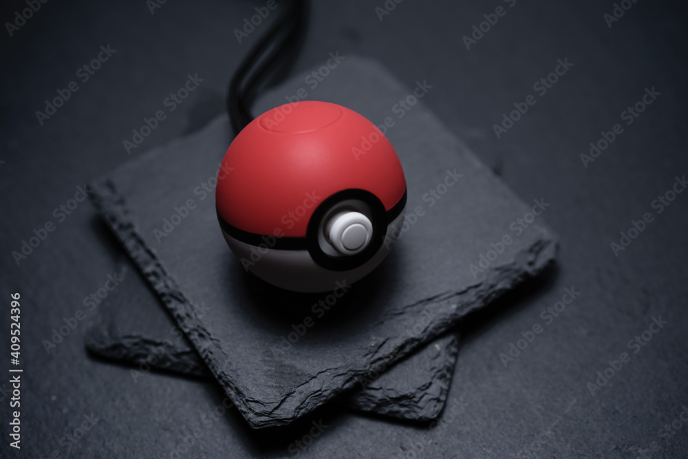 KUALA LUMPUR, MALAYSIA - JUNE 13TH, 2019 : A Poké Ball Plus on a black ...