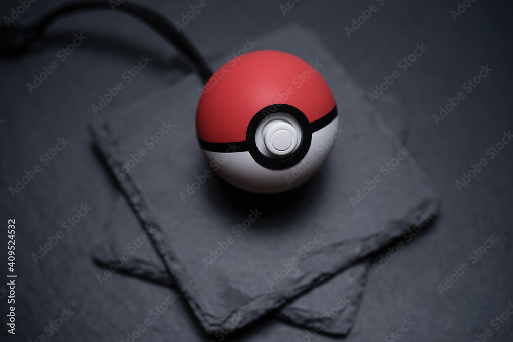 KUALA LUMPUR, MALAYSIA - JUNE 13TH, 2019 : A Poké Ball Plus on a black ...