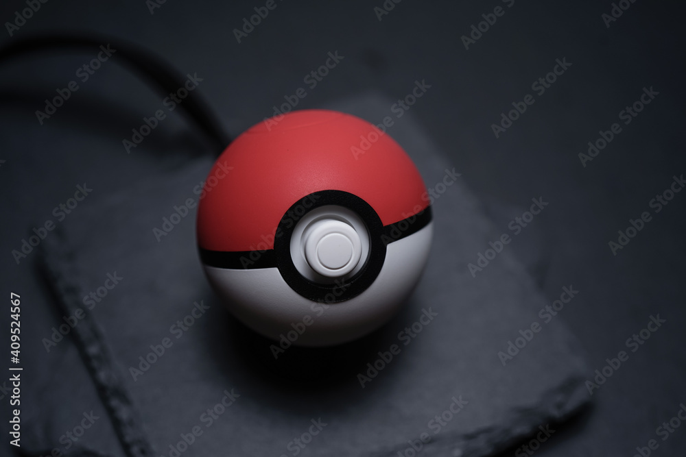 KUALA LUMPUR, MALAYSIA - JUNE 13TH, 2019 : A Poké Ball Plus on a black ...