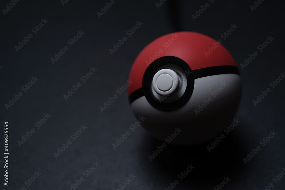 KUALA LUMPUR, MALAYSIA - JUNE 13TH, 2019 : A Poké Ball Plus on a black ...