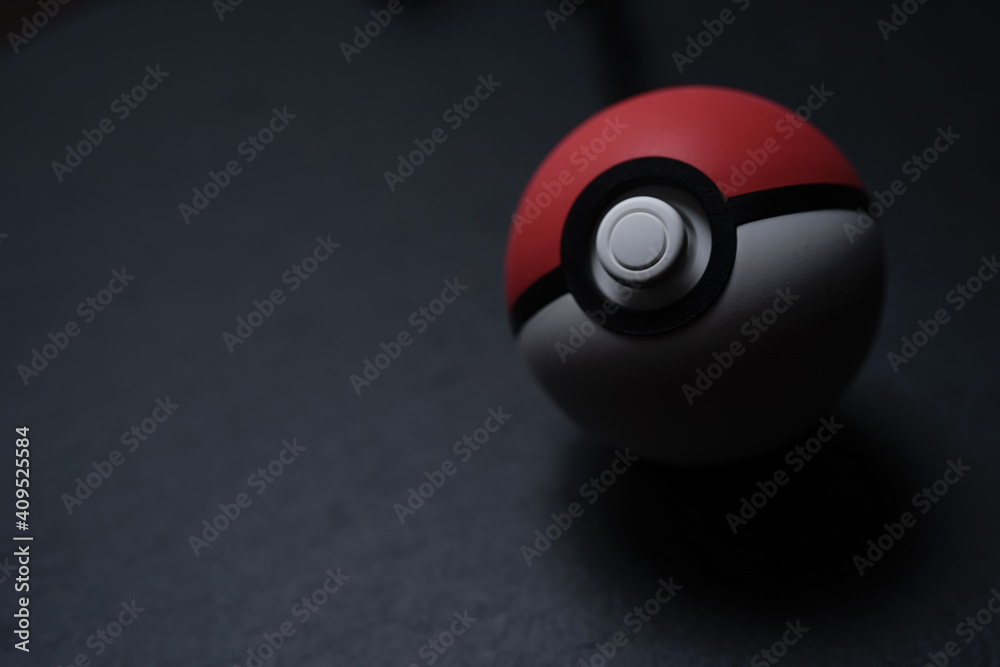 KUALA LUMPUR, MALAYSIA - JUNE 13TH, 2019 : A Poké Ball Plus on a black ...