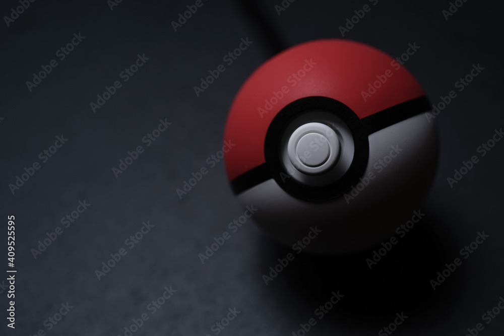KUALA LUMPUR, MALAYSIA - JUNE 13TH, 2019 : A Poké Ball Plus on a black ...