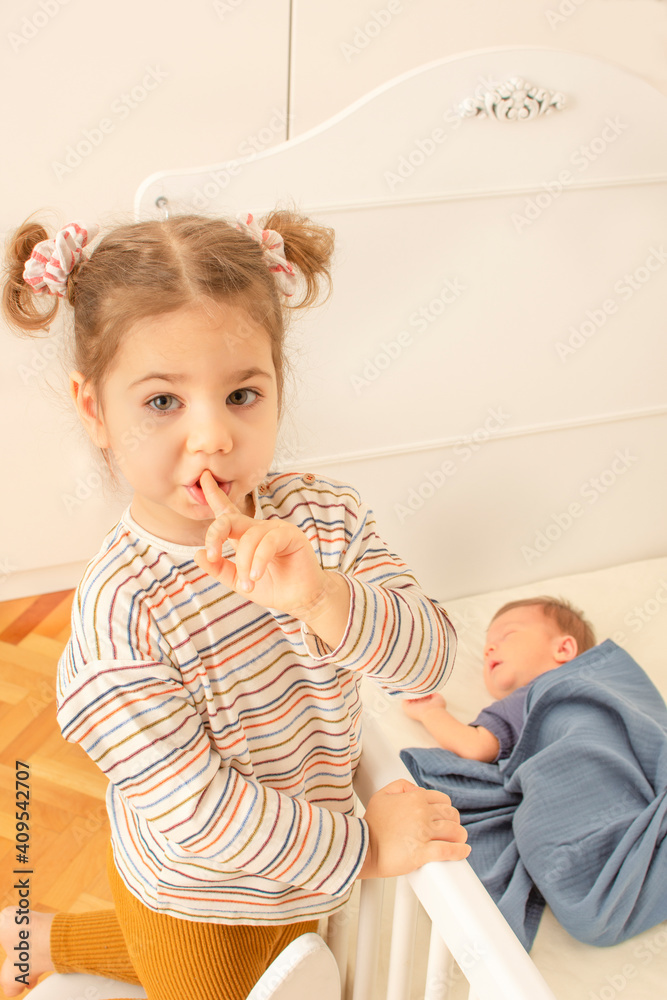 Cute portrait of toddler sister with baby brother. Little girl playing ...