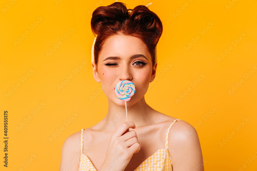 Elegant ginger girl licking lollipop. Front view of enthusiastic woman ...