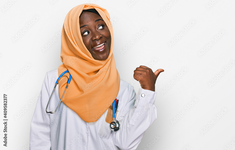 Foto de Beautiful african young woman wearing doctor uniform and hijab ...