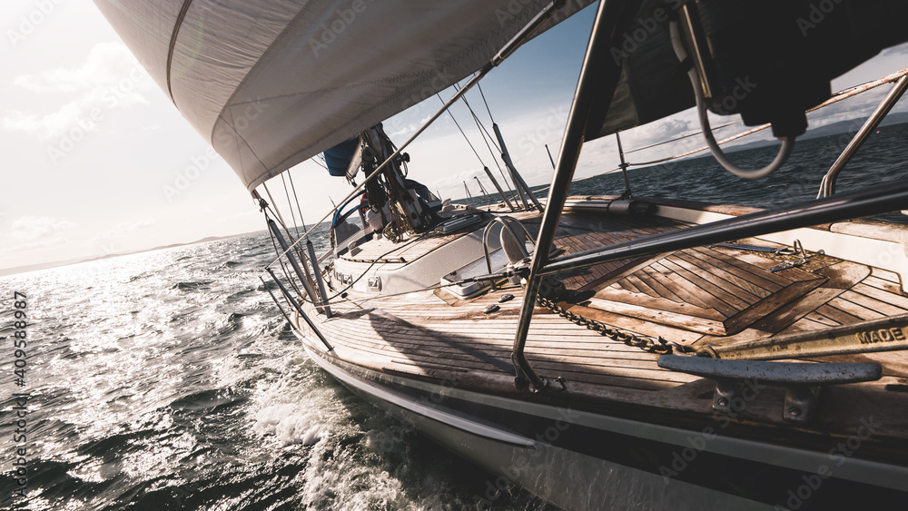 Sloop rigged modern yacht with wooden teak deck racing through the ...