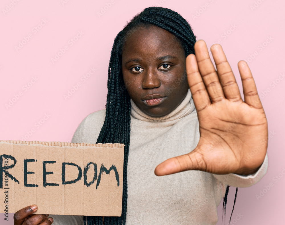 Young black woman with braids holding freedom banner with open hand ...