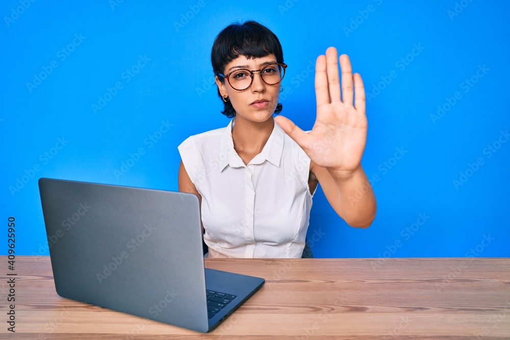 Beautiful brunettte woman working using computer laptop with open hand ...