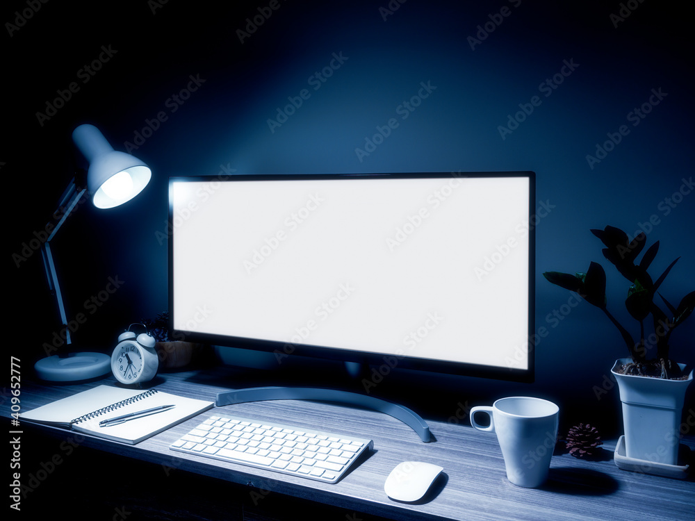 Blank white screen computer on the table and lamp in dark room at night ...