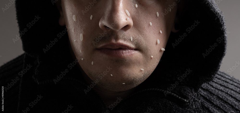 portrait of a male face covered with a lot of rice grains. Concept ...
