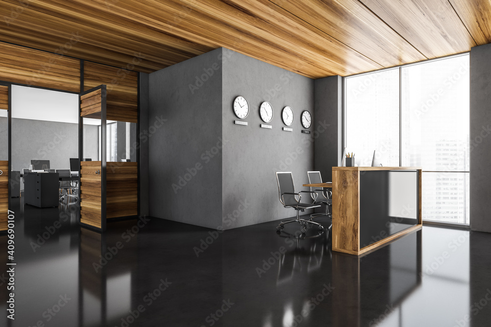 Corner of empty office, grey reception and wall, four clocks on it ...