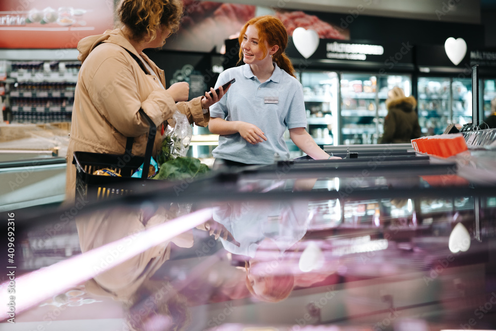 Customer asking supermarket employee for help finding a food item Stock ...
