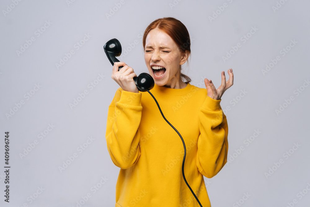 Crazy angry young woman in stylish yellow sweater talking on retro ...