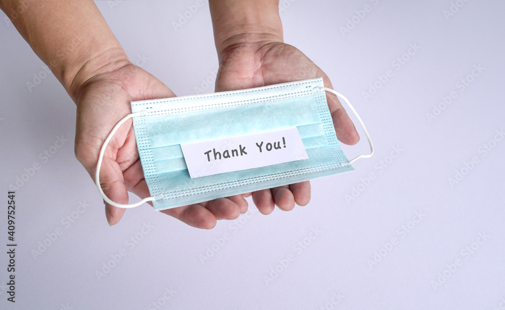 Thank you note on top of face mask, on palm of man's hands Stock Photo ...