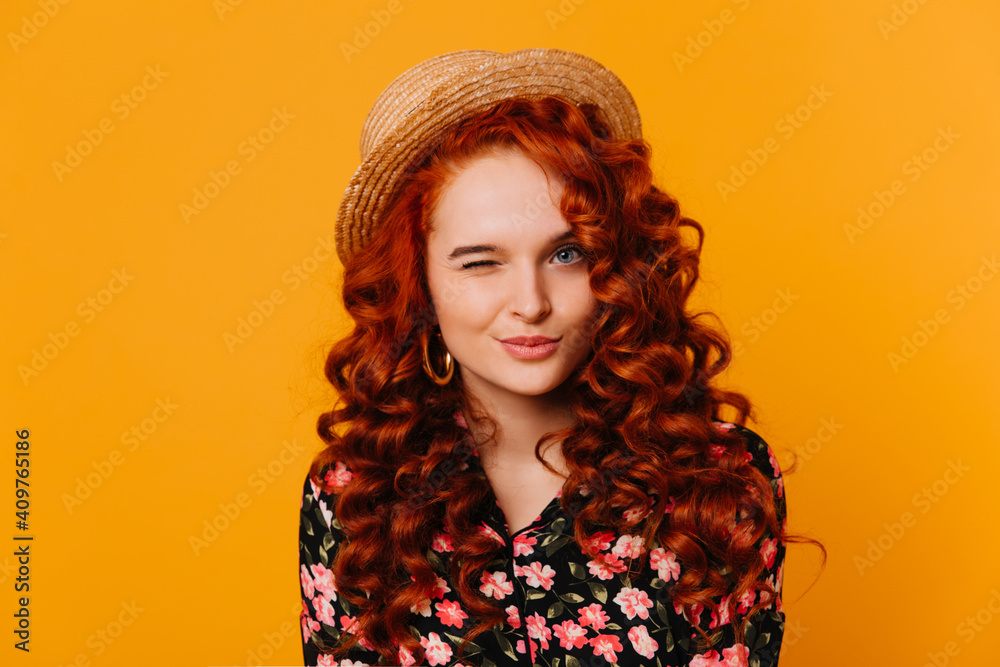 Pretty woman with mole at corner of her lips winks. Portrait of blue ...