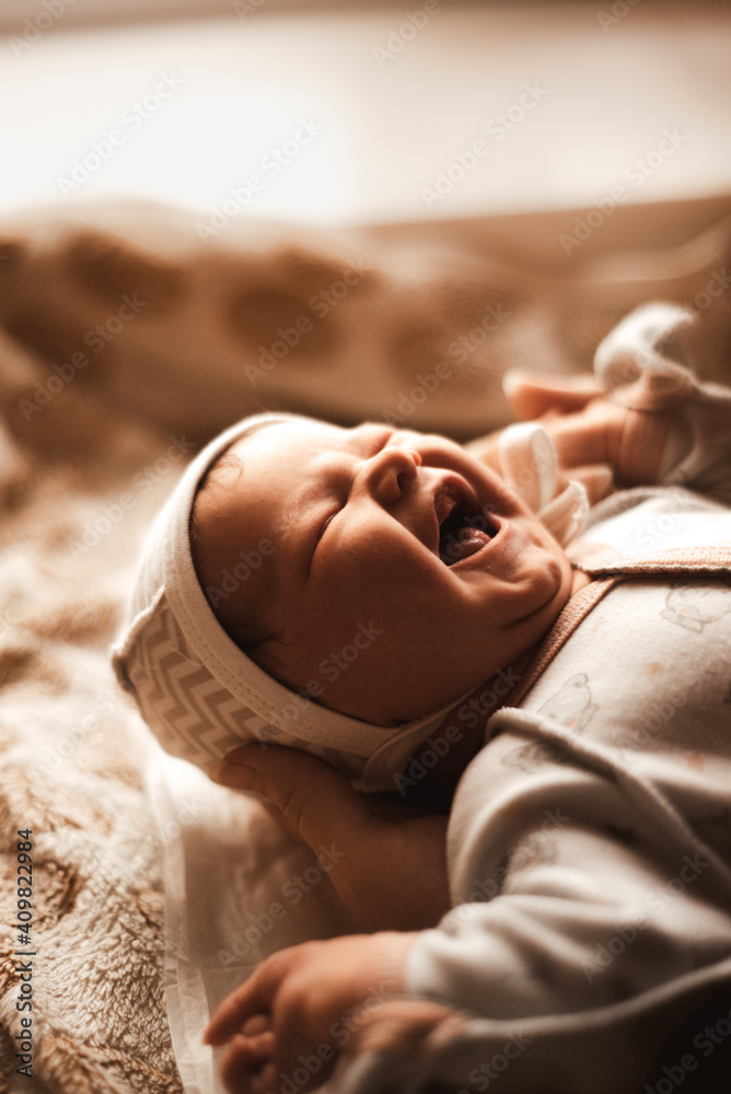 Newborn baby crying in the arms of the mmam. The first days of life ...