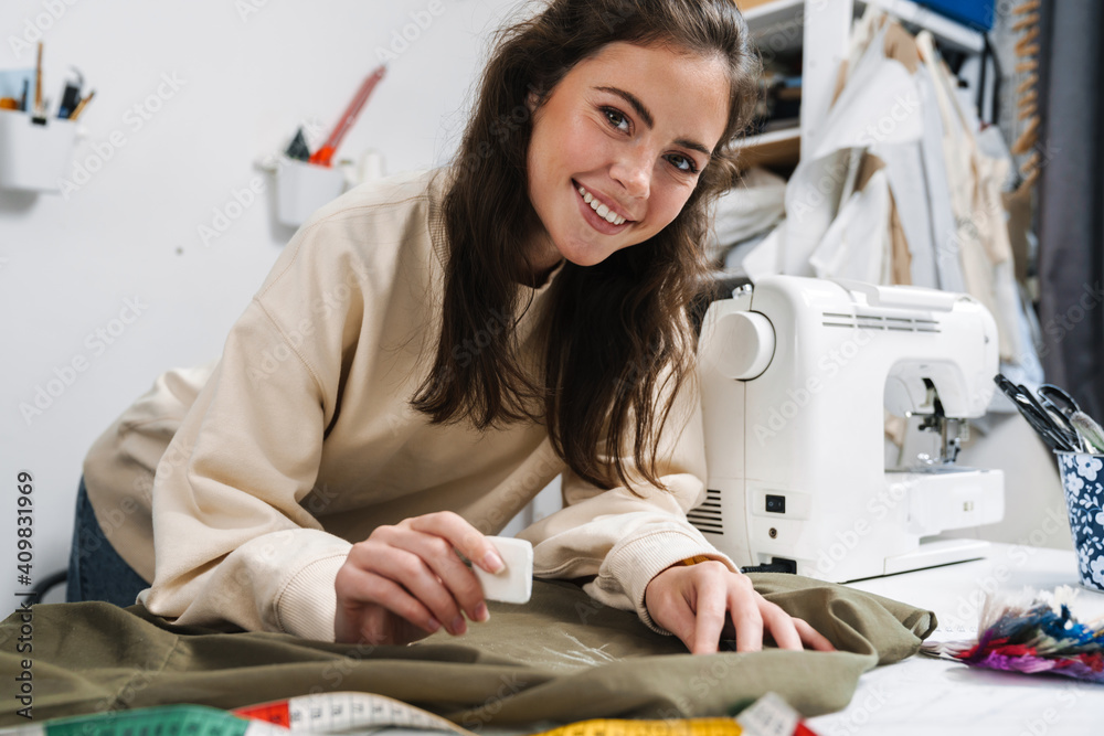 Portrait of happy seamstress sewing in the workshop Stock Photo | Adobe ...