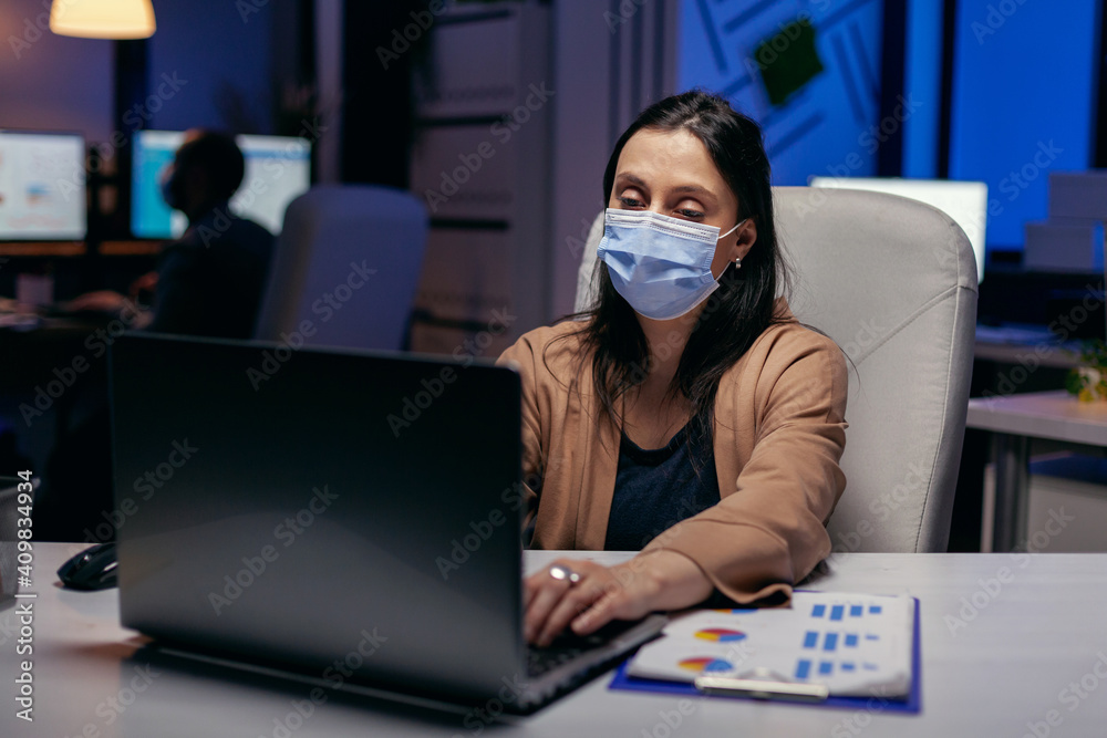 Overworked businesswoman wearing face mask as safety precautiond due to ...