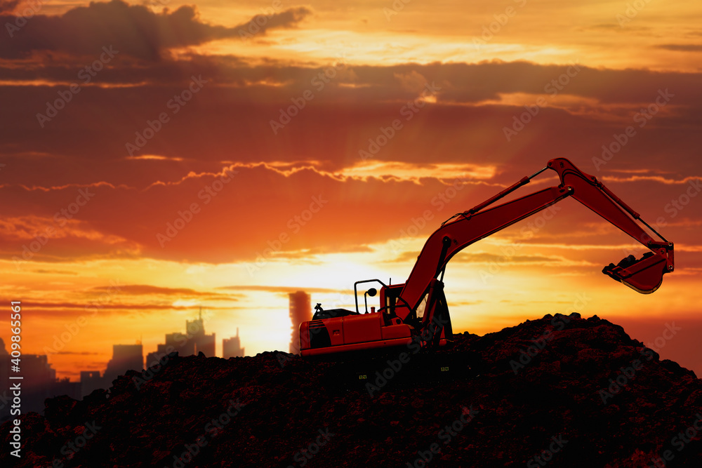 Excavators are digging the soil in the construction site on the sunset ...