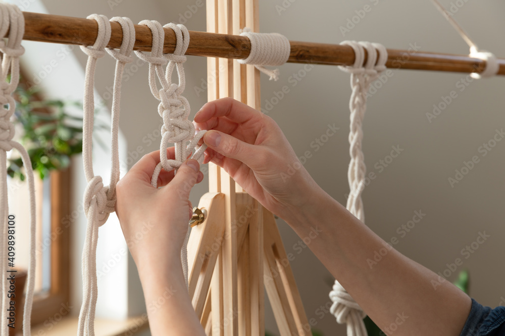 Foto de Woman relaxing and making macrame at home with different knots ...