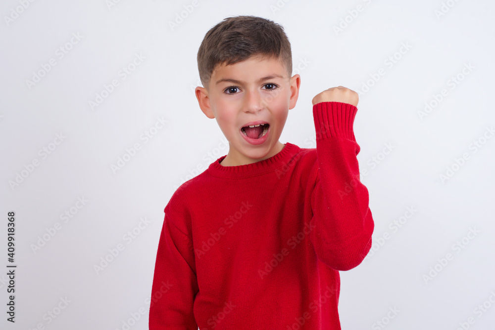 Fierce Little cute boy kid wearing red knitted sweater against white ...