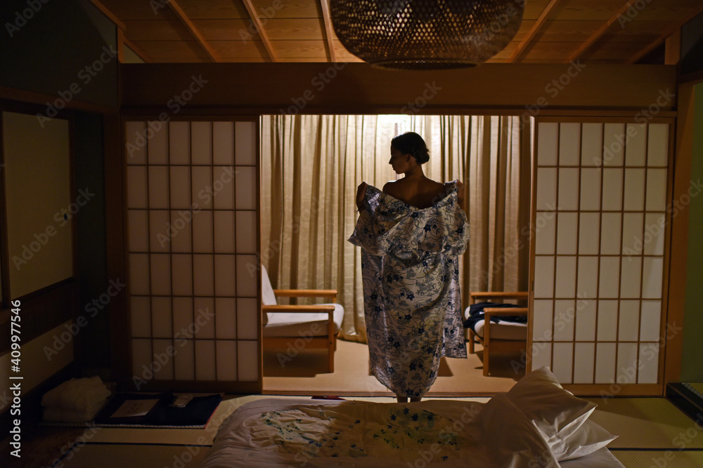 Young caucasian woman in Japanese kimono undressing at night in ...