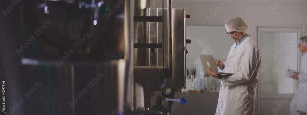 Side view of man wearing protective workwear setting up process values ...