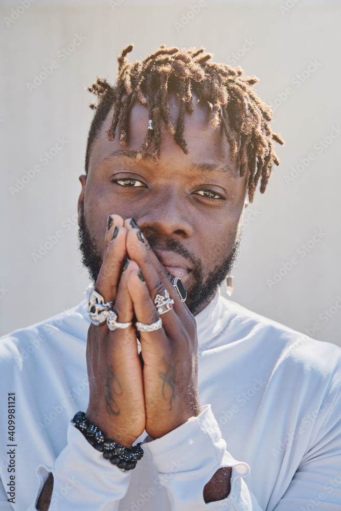Calm African American male with dreadlocks and hands with rings and ...