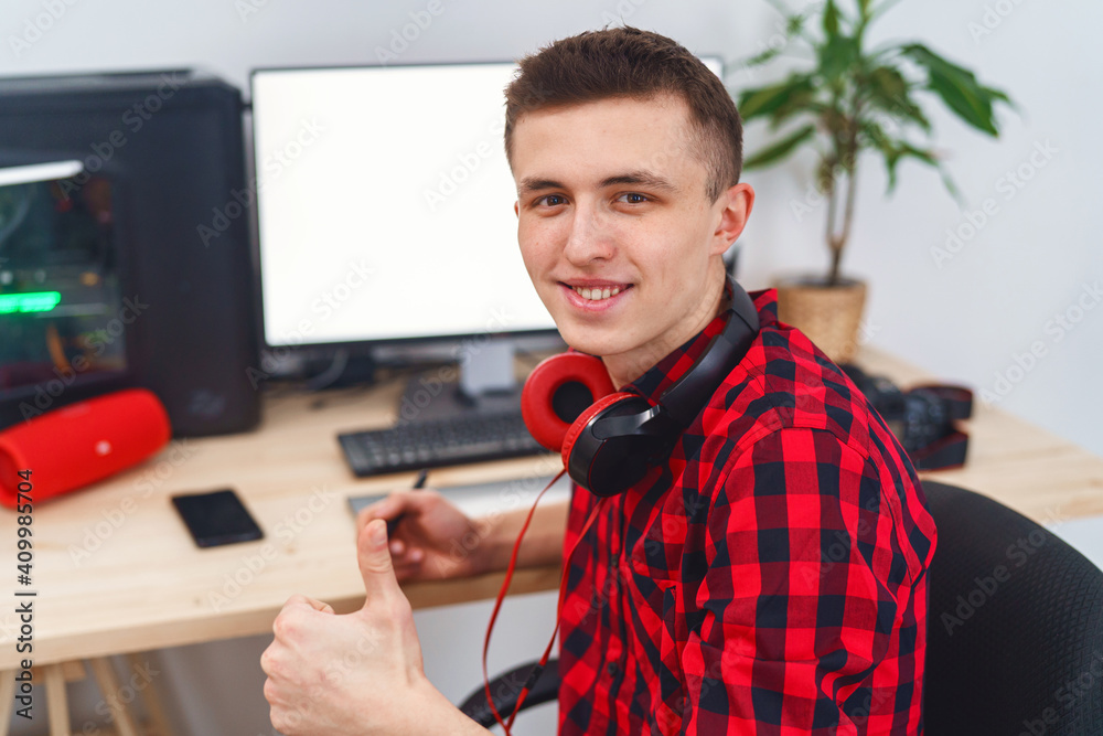 portrait smiling freelancer working with headphones on using pen tablet ...