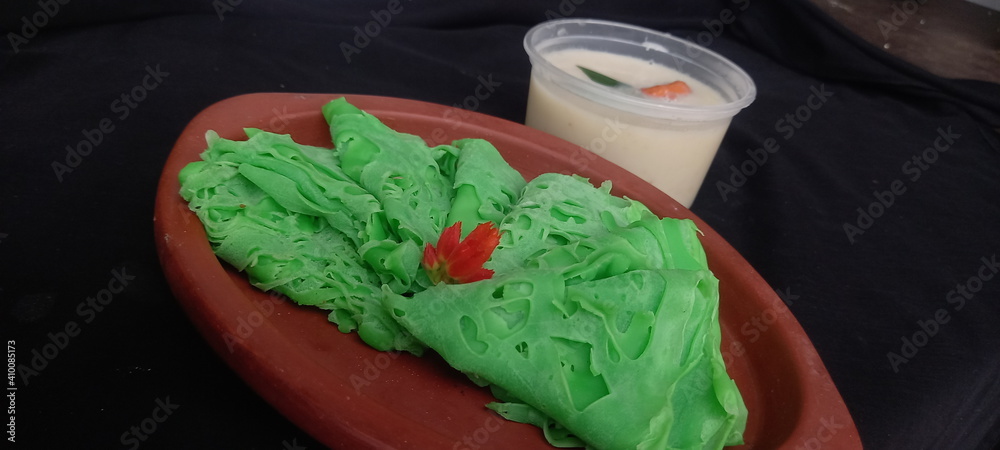 Pandan-flavored green jala bread eaten with durian sauce. Stock Photo ...