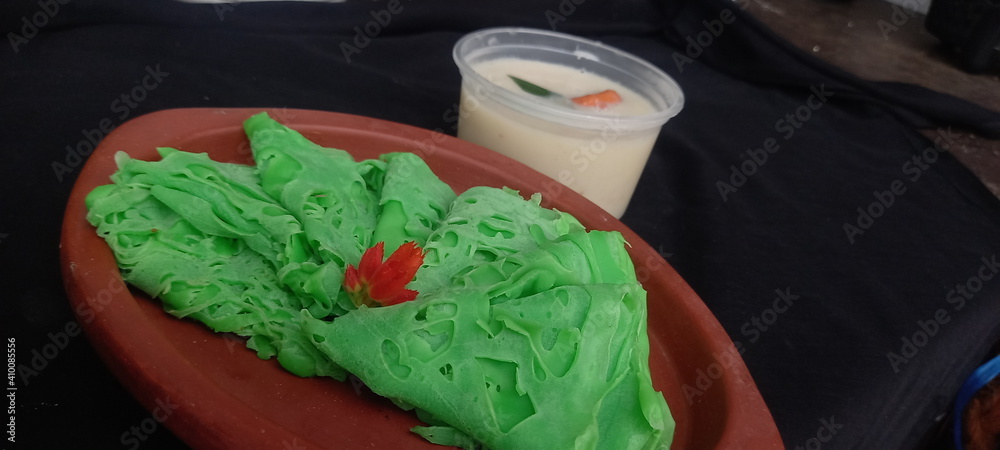 Pandan-flavored green jala bread eaten with durian sauce. Stock Photo ...