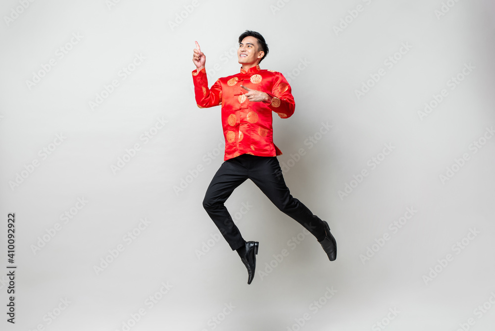 Jumping portrait of smiling handsome Asian man in traditional oriental ...