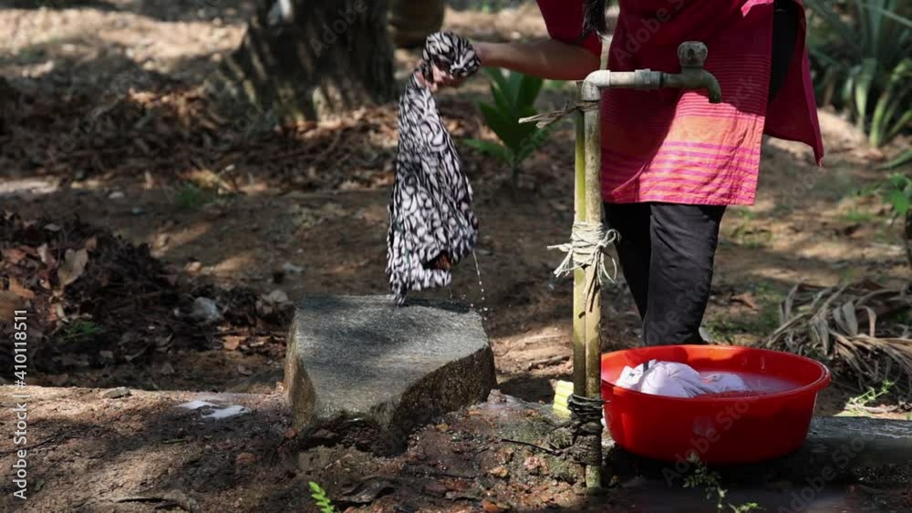 Women's hands washing dirty clothes beating on stone with detergent ...