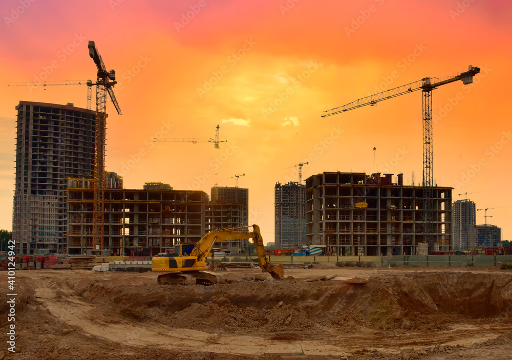 Excavator during earthmoving work at construction site on sunset ...